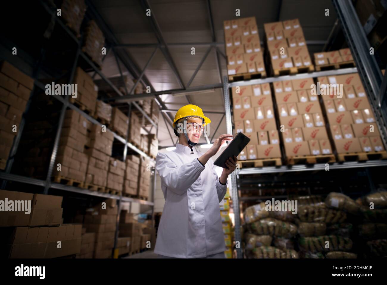 Young cute cheerful female engineer is using tablet for final ...