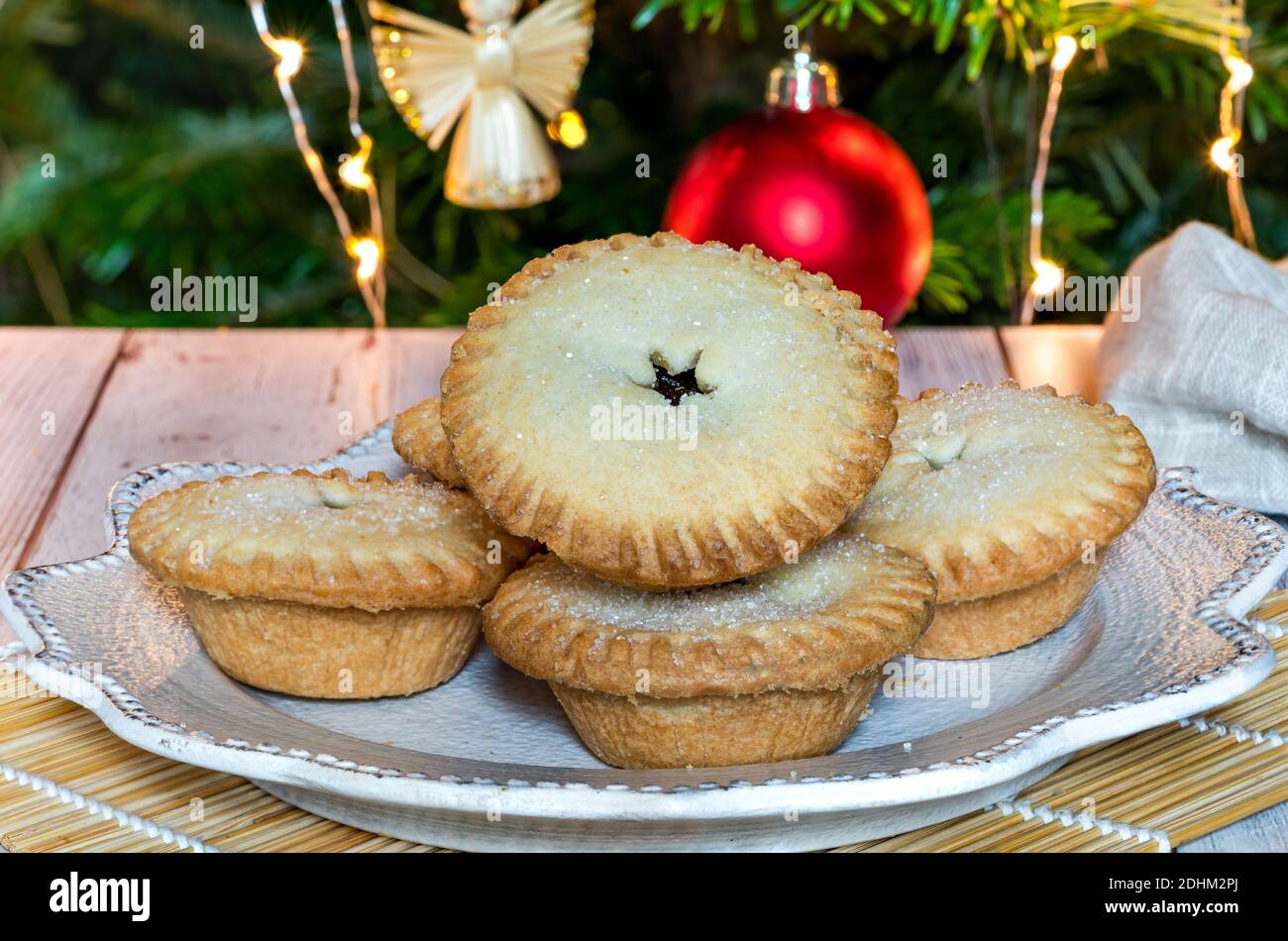 Traditional Christmas mince pies with decorated Christmas tree in the ...