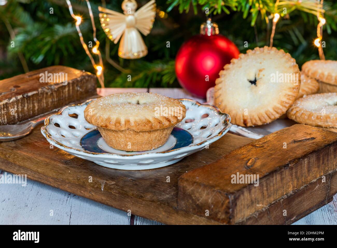 Traditional Christmas mince pies with decorated Christmas tree in the ...