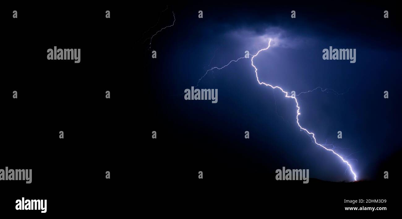 Bright lightning bolt on mountain with radio tower for power and ...