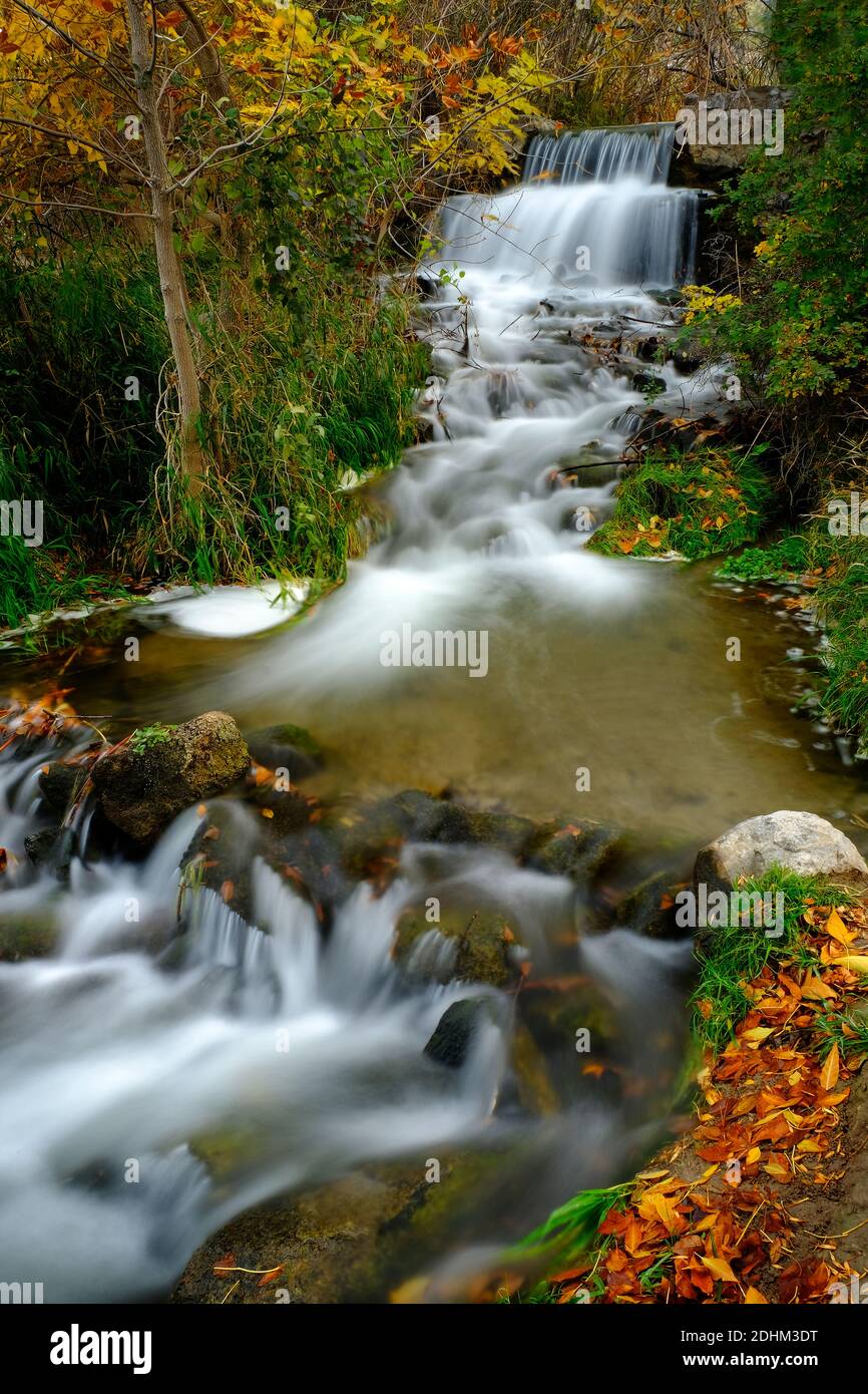 Waterfall of flowing water from stream or creek with fall autumn leaves ...