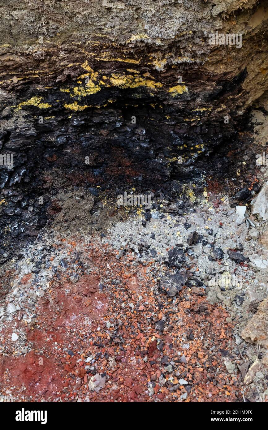 Red baked earth, called clinker, char, and sulfur from a 2020 coal seam ...