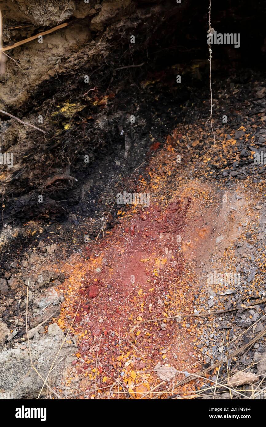 Red baked earth, called clinker, from a 2020 coal seam fire burning ...