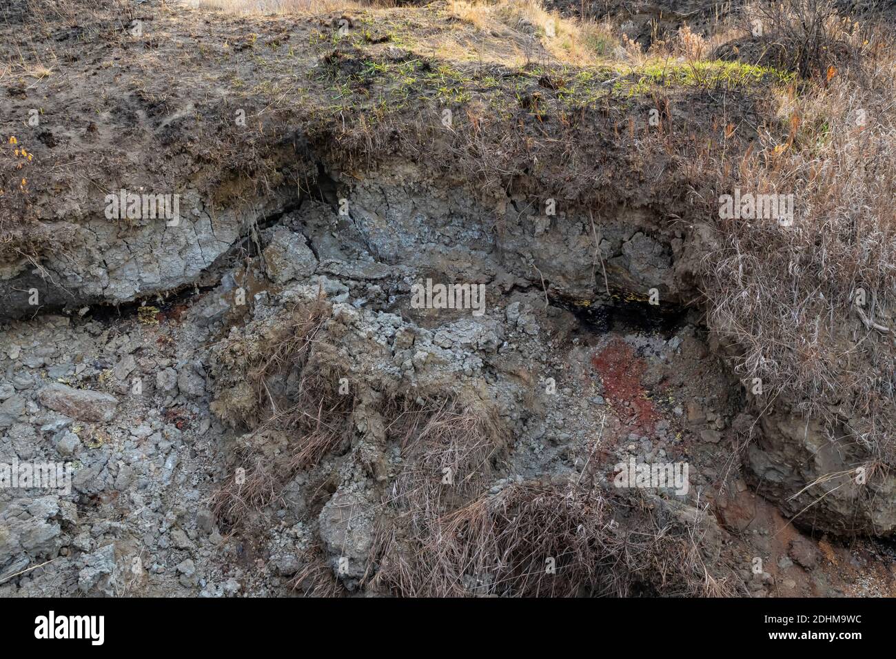 Red baked earth, called clinker, from a 2020 coal seam fire burning ...