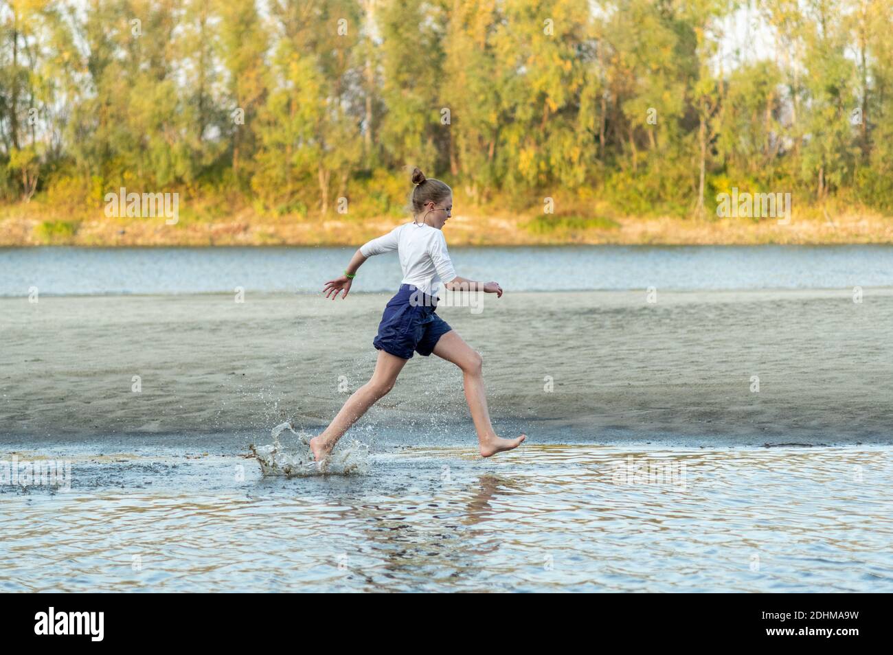 The girl takes a big step. The girl plays in the water. Have fun in the ...