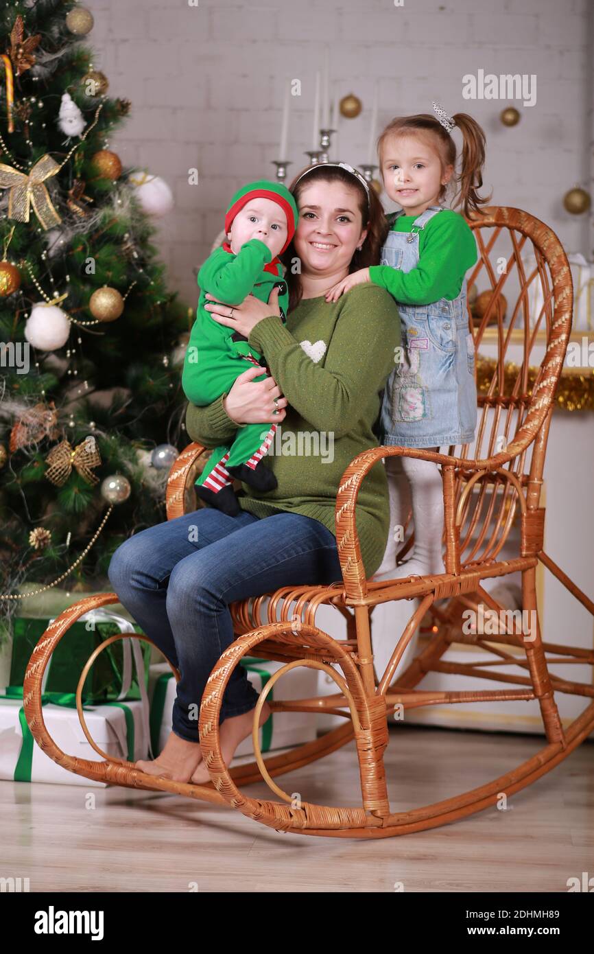 young beautiful mother with her baby son in elf costume and little girl ...