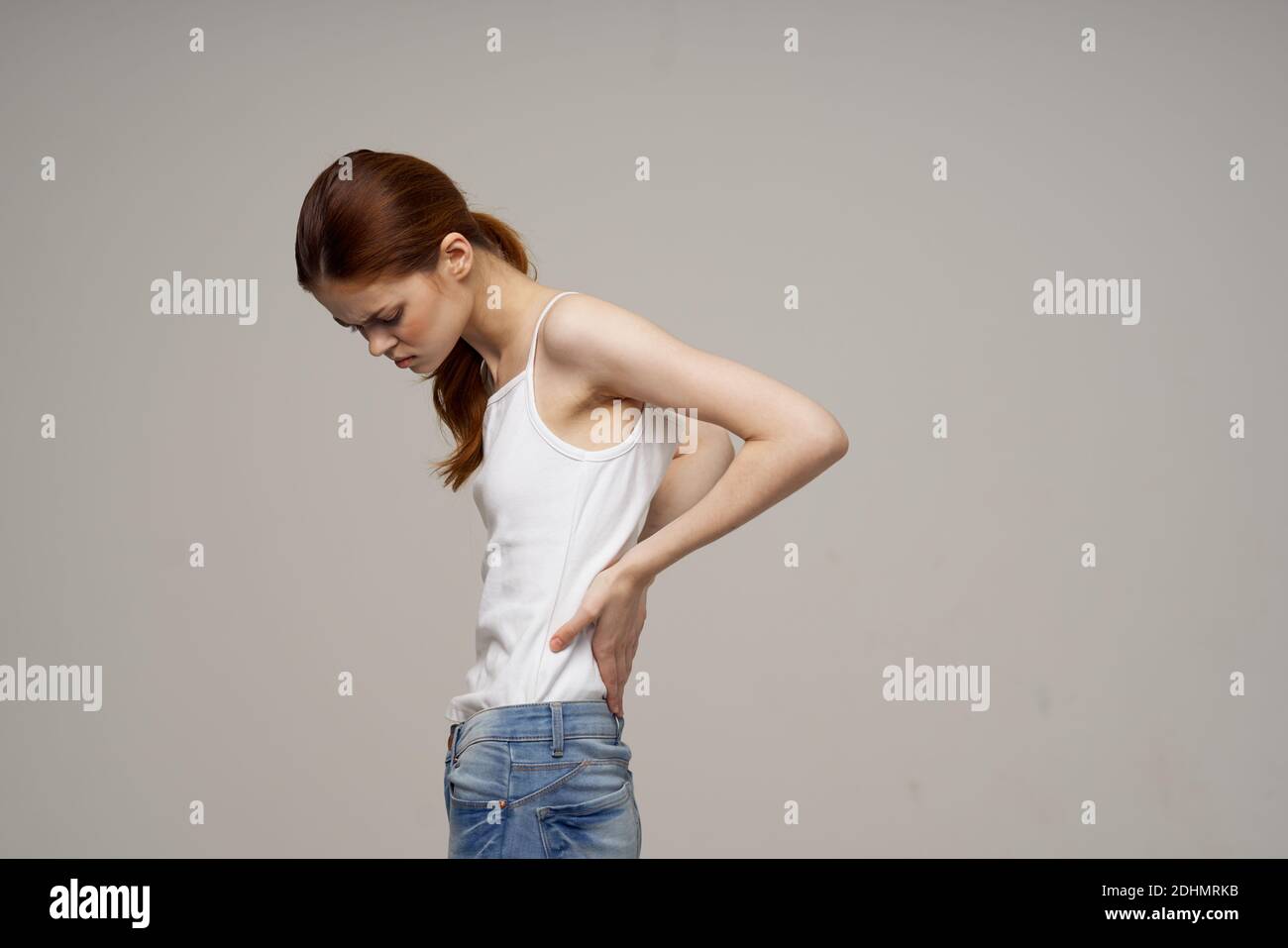 woman holding hands on belt posing emotions studio isolated background ...