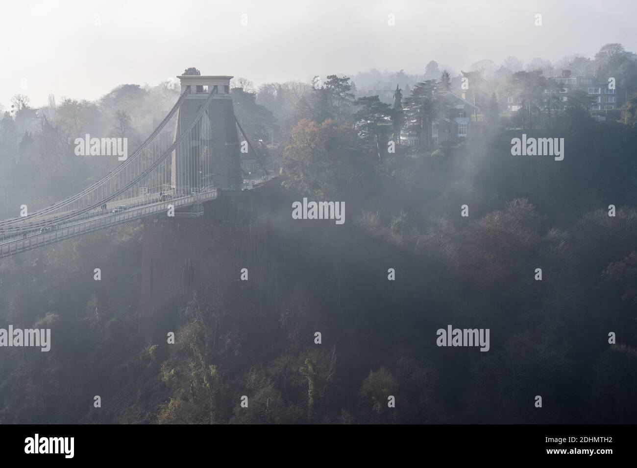 Autumn mist rises from trees beside the Clifton Suspension Bridge at ...