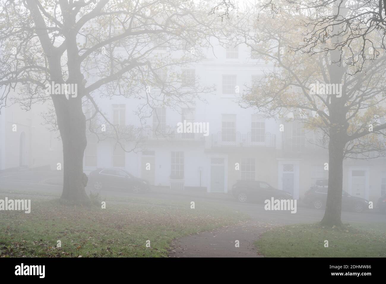 Grand townhouses and trees displaying autumn colours fade into fog on ...