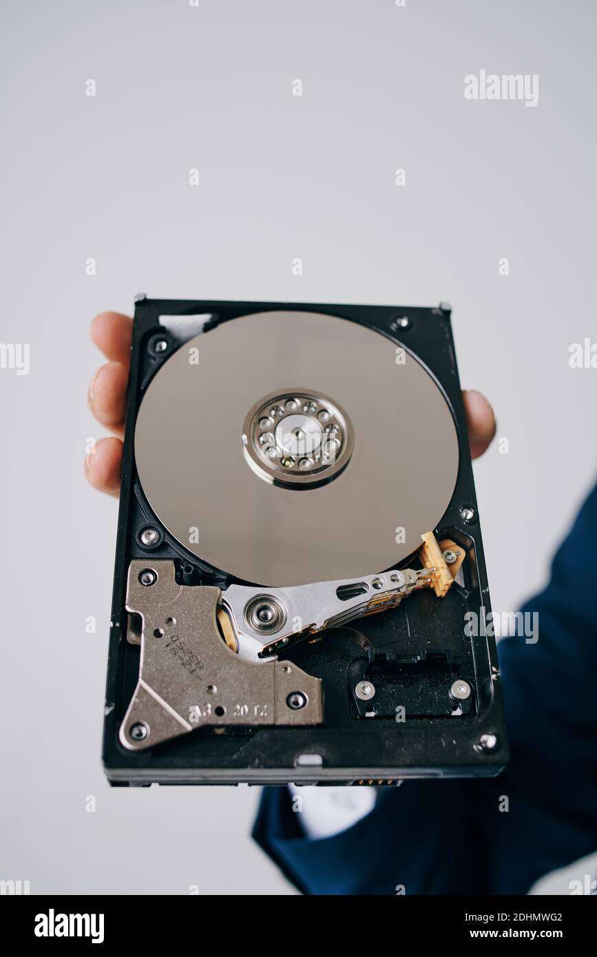 hard drive disassembled in a man's hand on a gray background Stock ...