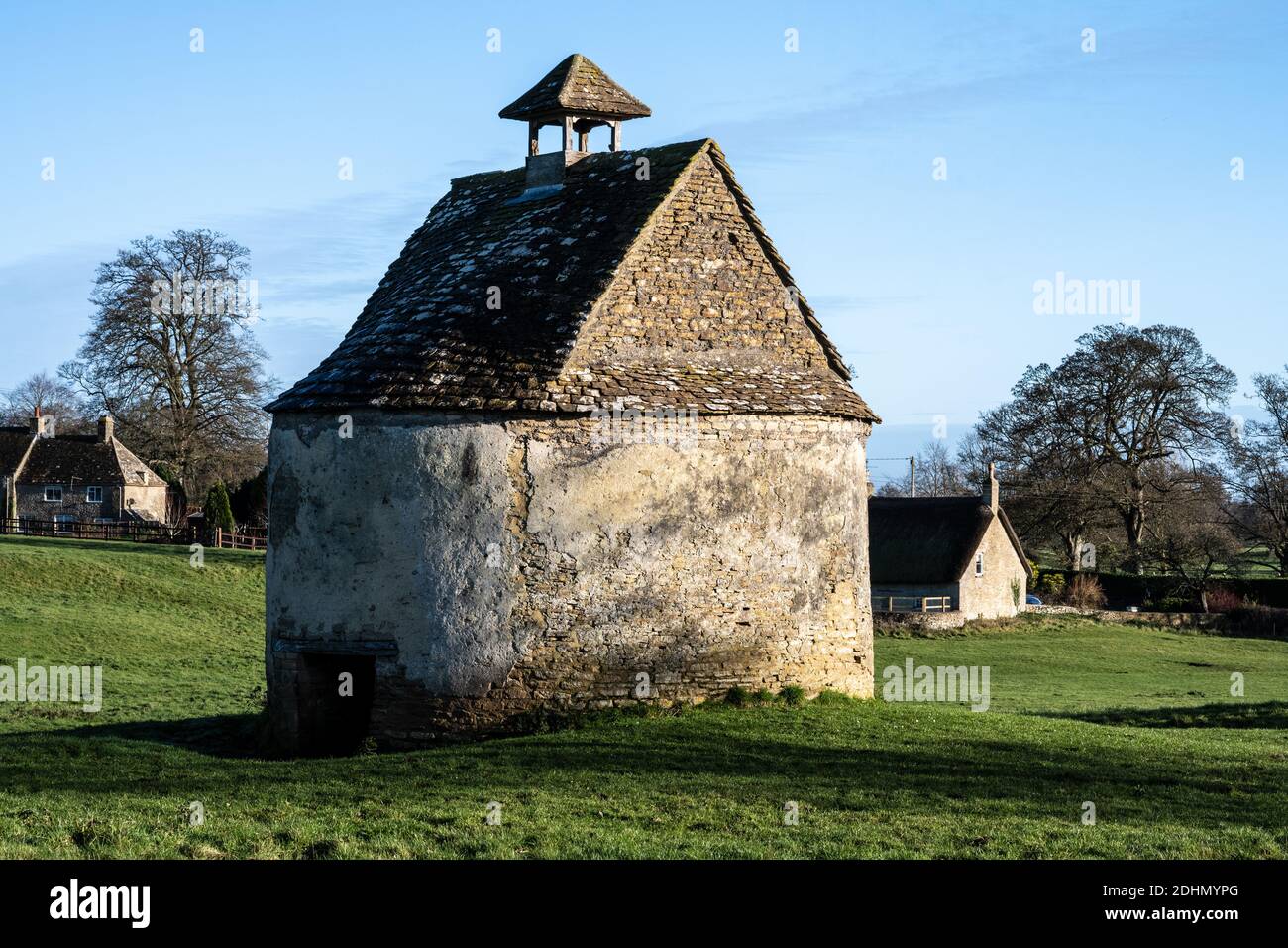 A traditional old stone dovecote stands in a field in the Cotswolds ...