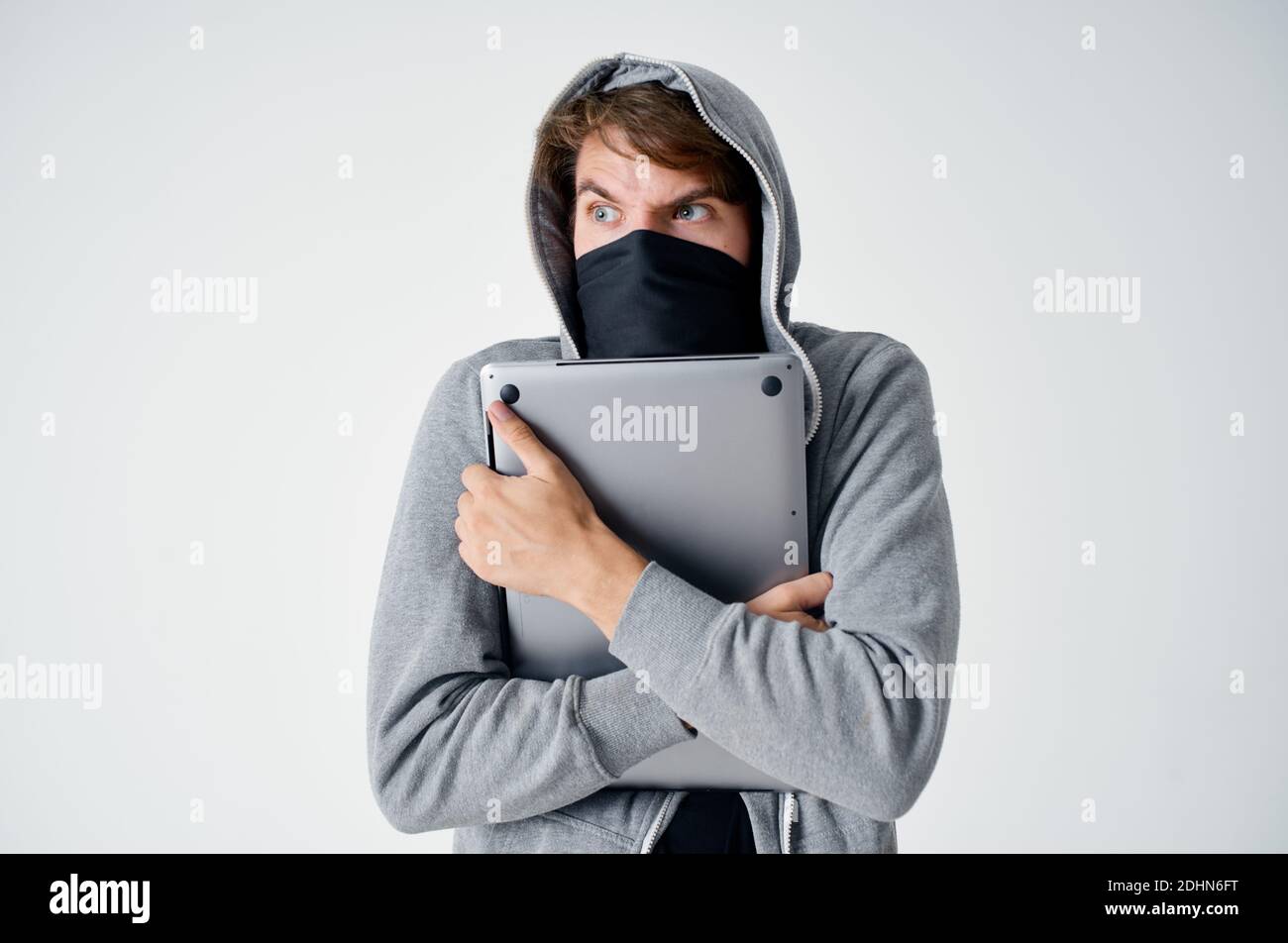 secretive masked man laptop hacker penetration danger Stock Photo - Alamy