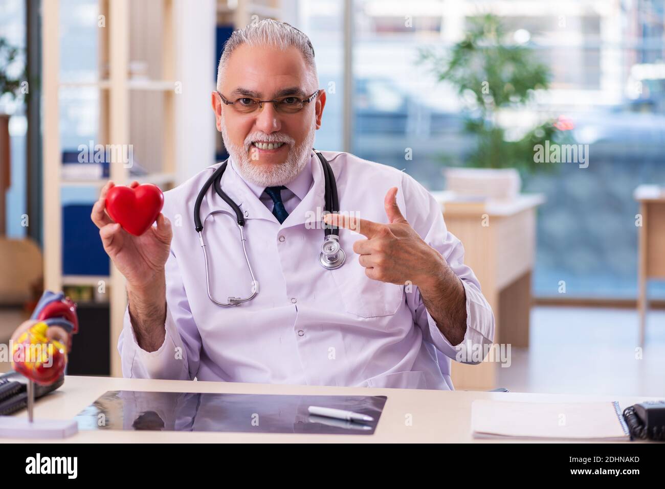 Old doctor cardiologist working in the clinic Stock Photo - Alamy