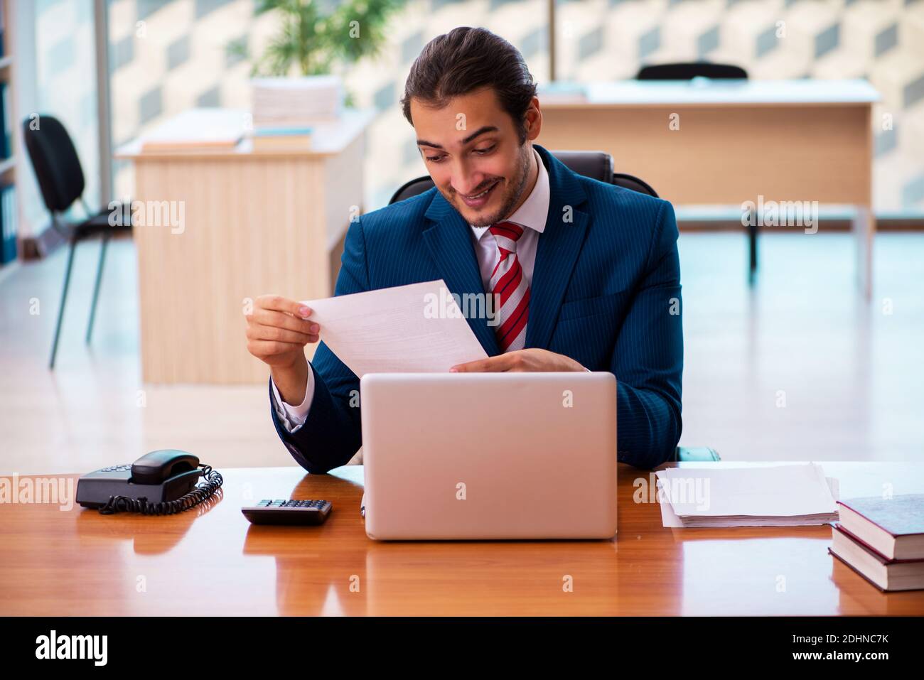 Young attractive male employee working in the office Stock Photo - Alamy