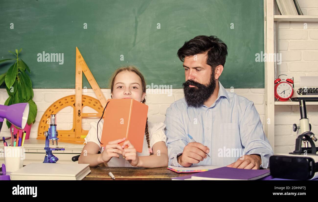 Explaining science to child. School teacher and schoolgirl. Man bearded ...