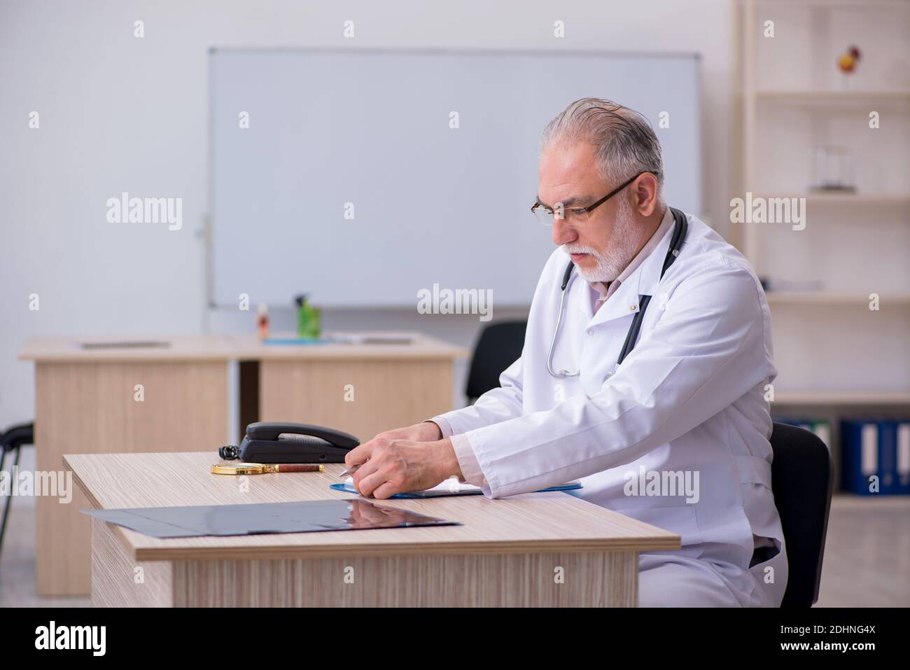 Old doctor working in the clinic Stock Photo - Alamy