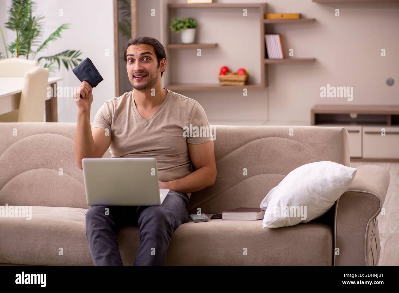 Young freelancer holding wallet at home Stock Photo - Alamy
