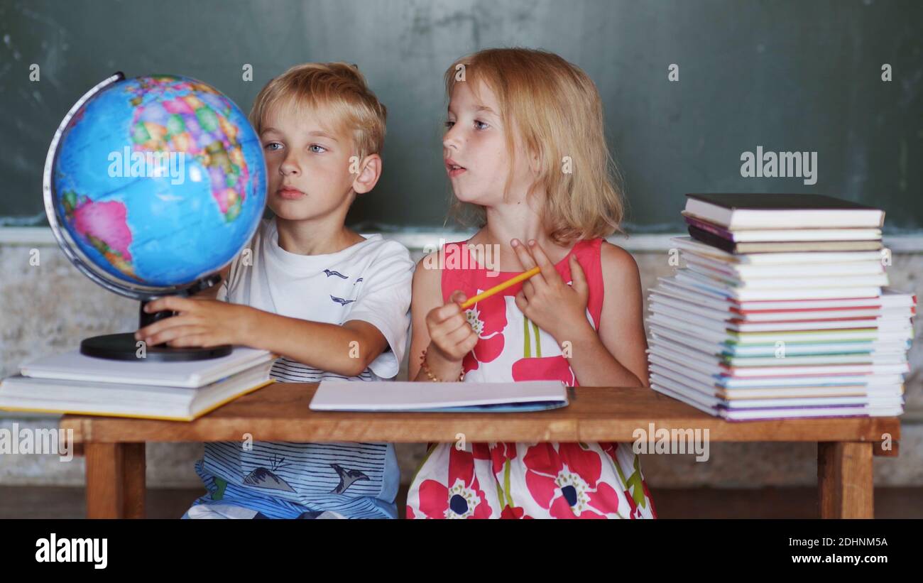 Brother and sister study at home with a world globe Stock Photo - Alamy