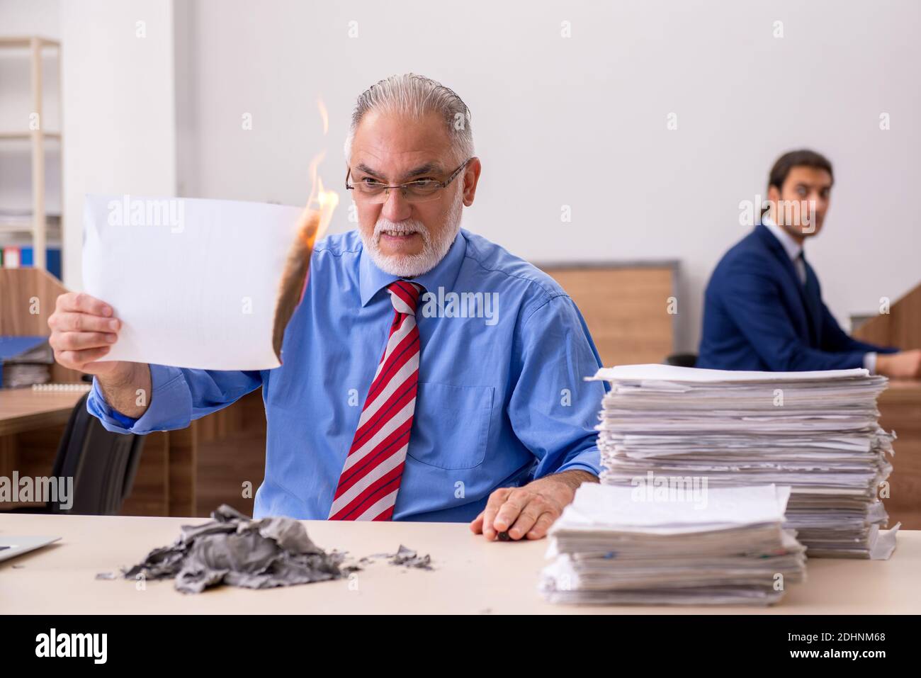 Male employee and his old boss burning papers at workplace Stock Photo ...