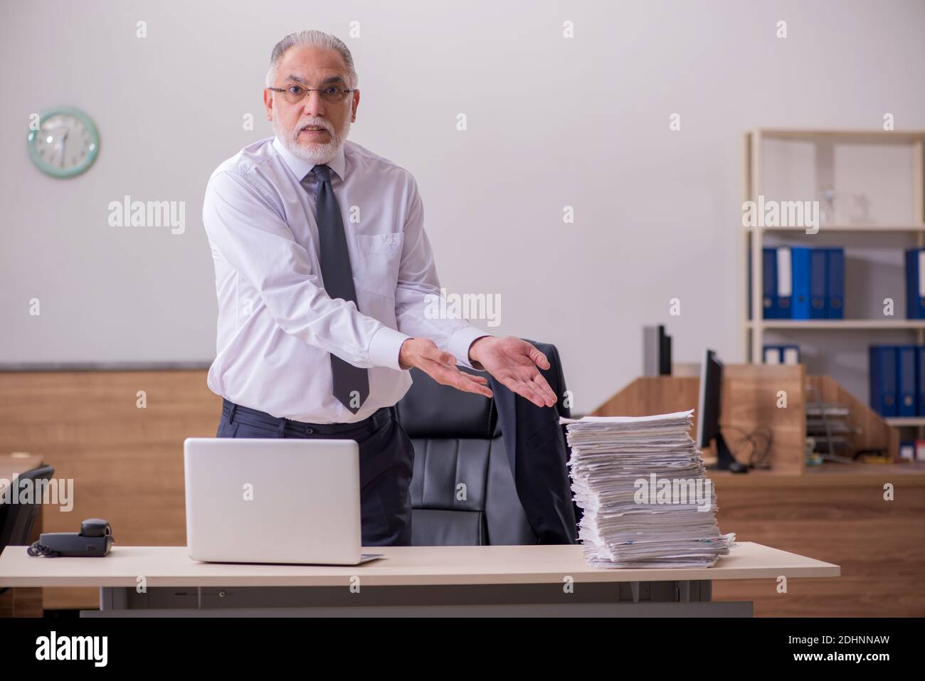 Old employee unhappy with excessive work in the office Stock Photo - Alamy