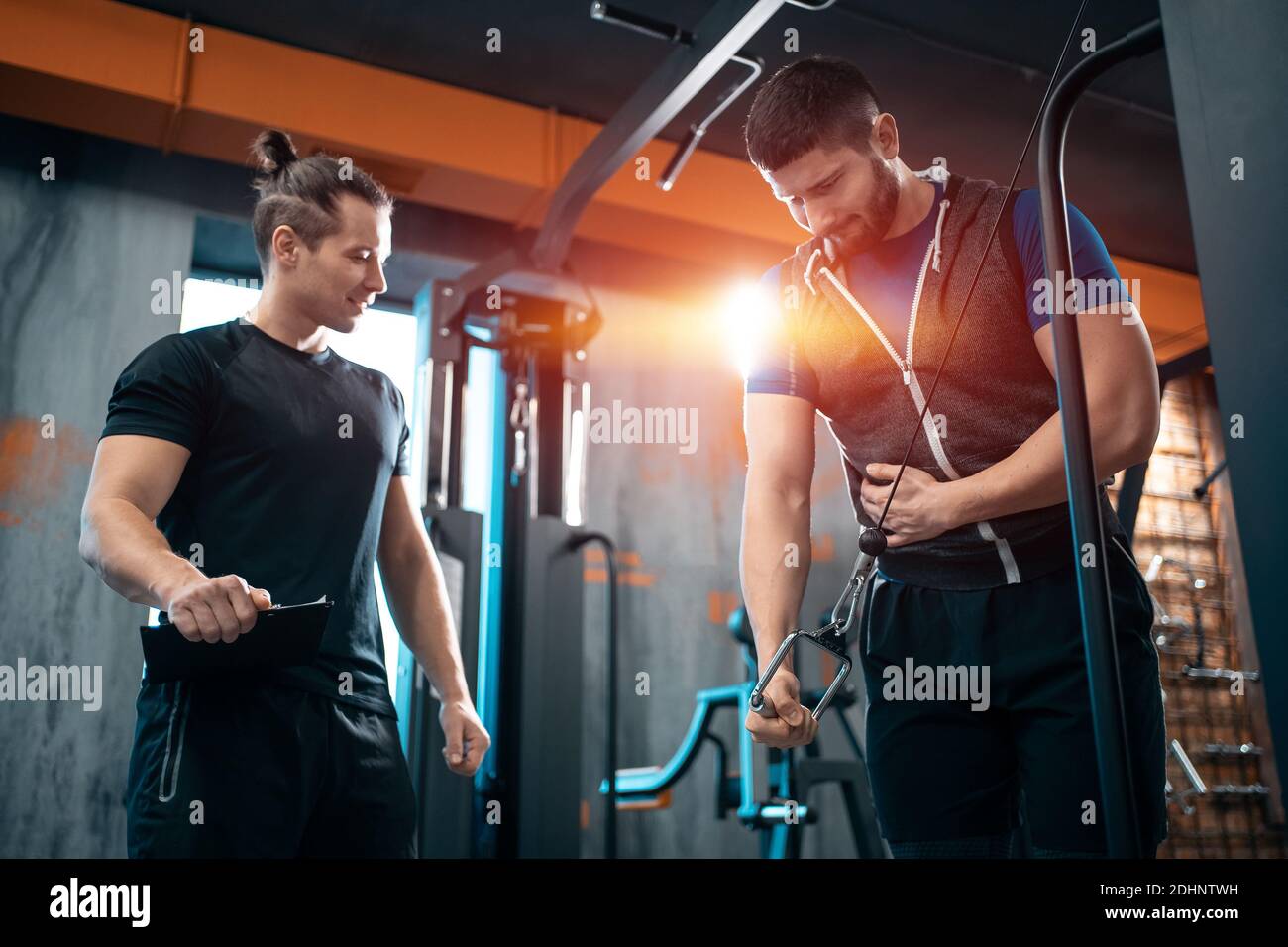 young man has workout with personal trainer in modern gym Stock Photo ...