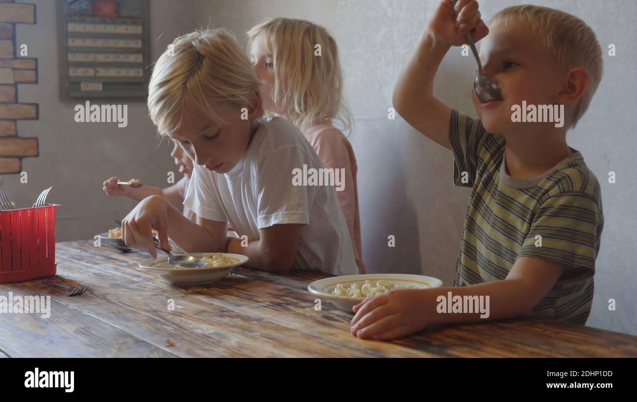 Funny children eat lunch at home Stock Photo - Alamy