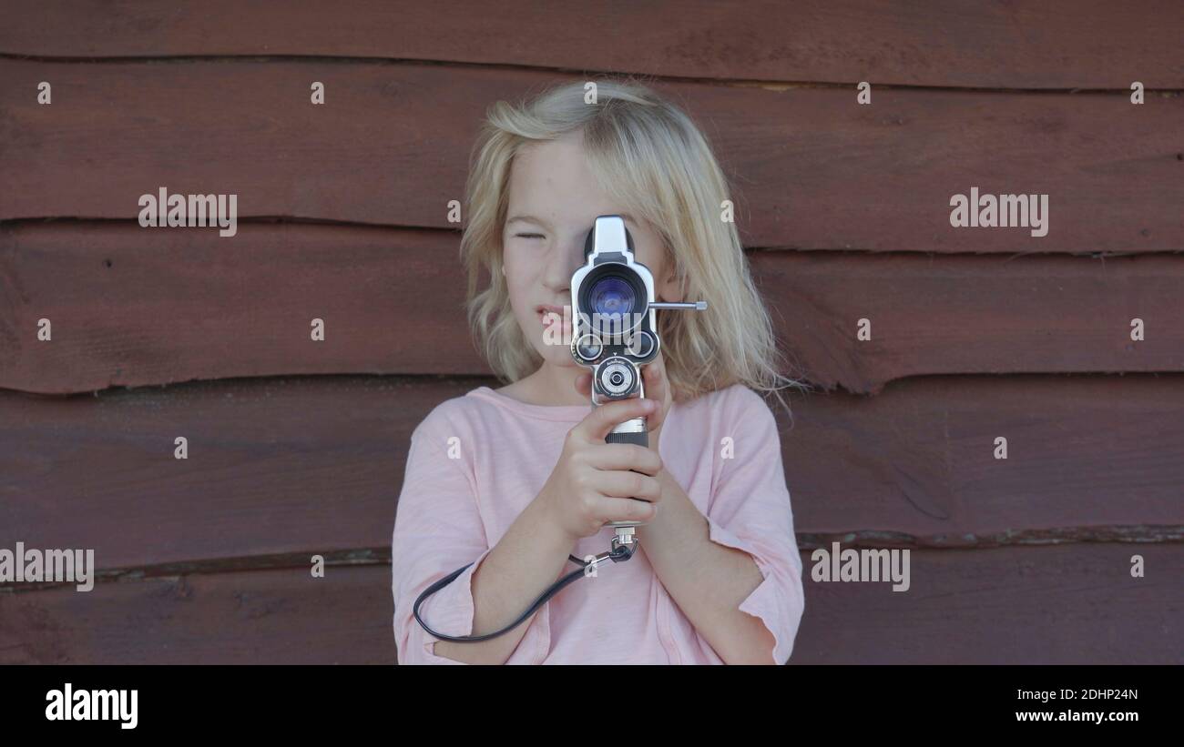 A little girl shoots a video of an old retro camera Stock Photo - Alamy