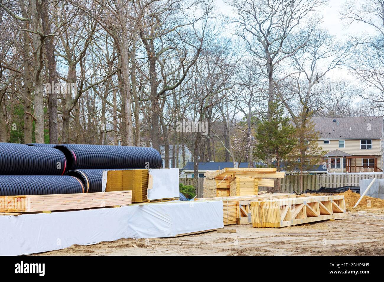 Plastic PVC pipes stacked at wooden building materials stack of boards ...