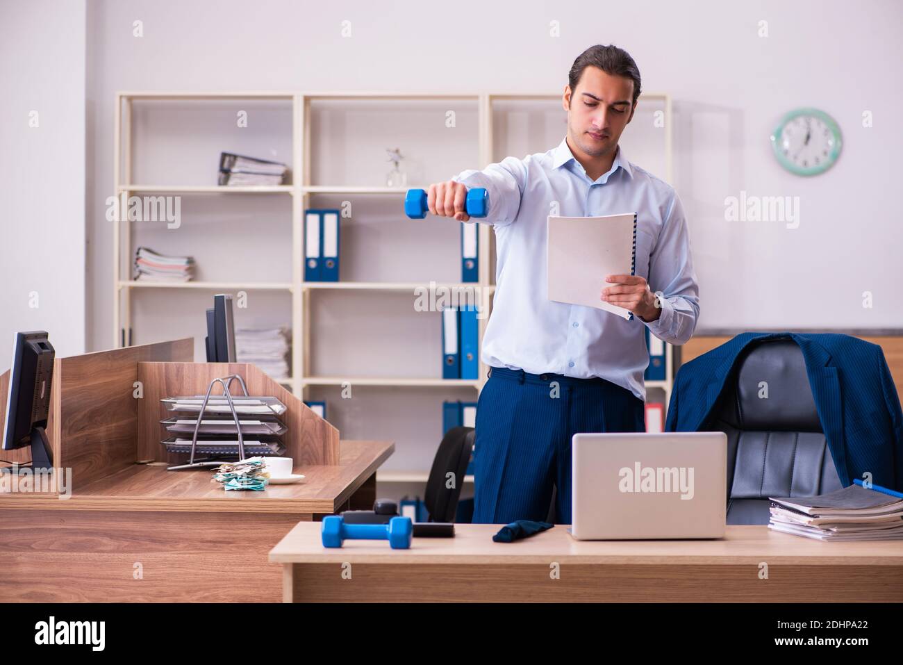 Young employee doing physical exercises at workplace Stock Photo - Alamy