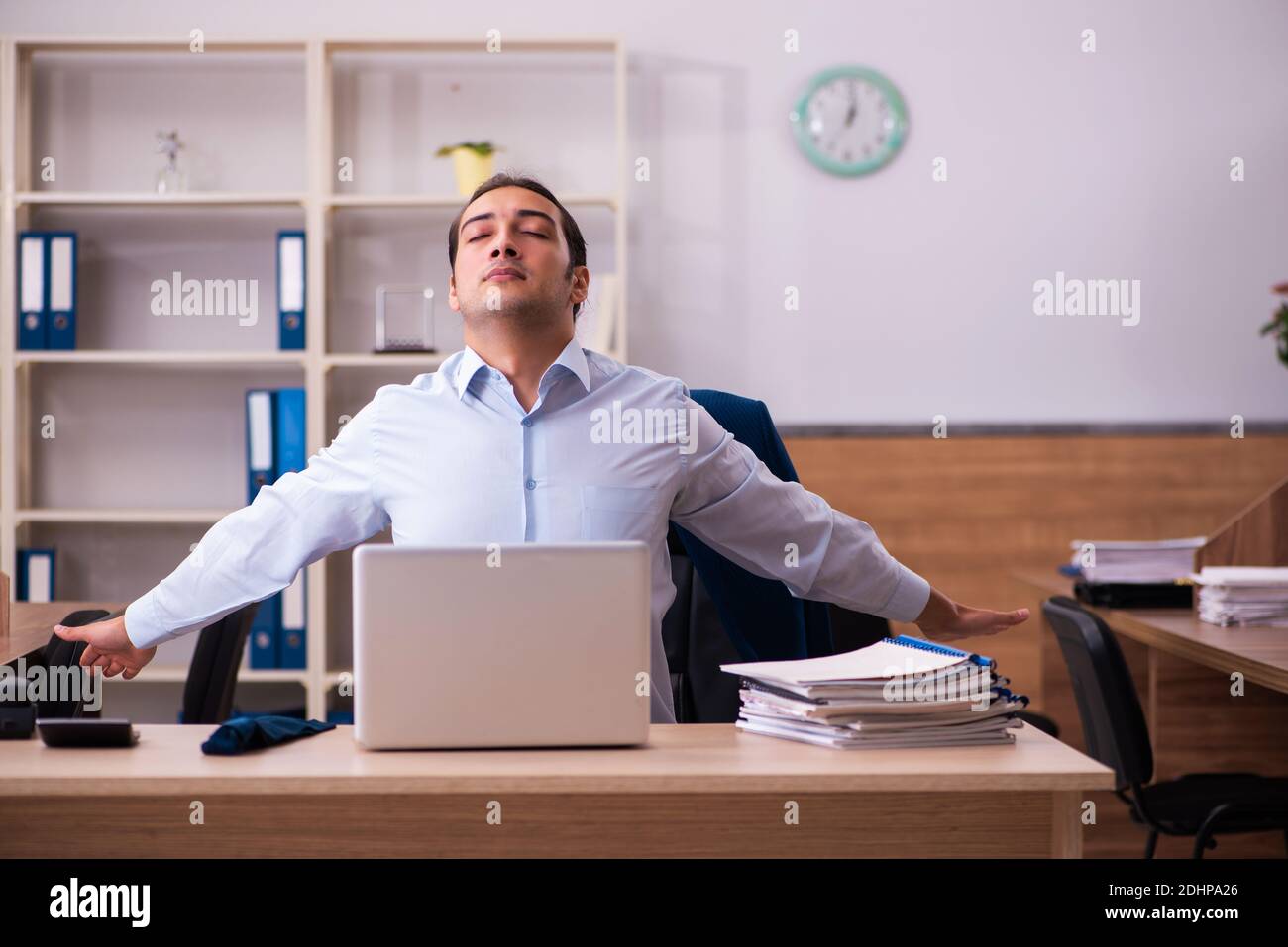 Young employee doing physical exercises at workplace Stock Photo - Alamy