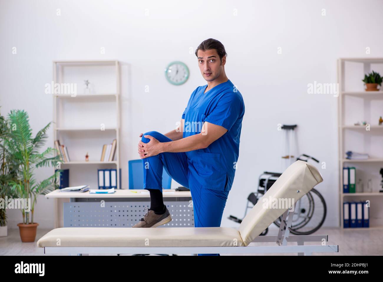 Young doctor physiotherapist doing sport exercises Stock Photo - Alamy