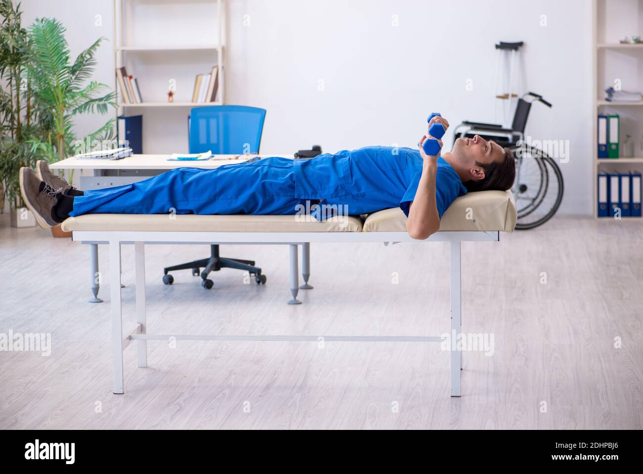 Young doctor physiotherapist doing sport exercises Stock Photo - Alamy