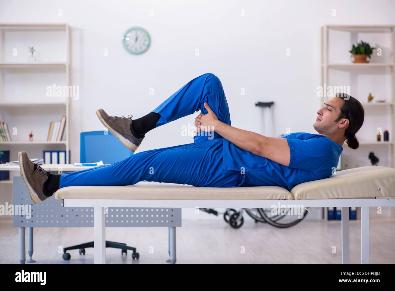 Young doctor physiotherapist doing sport exercises Stock Photo - Alamy