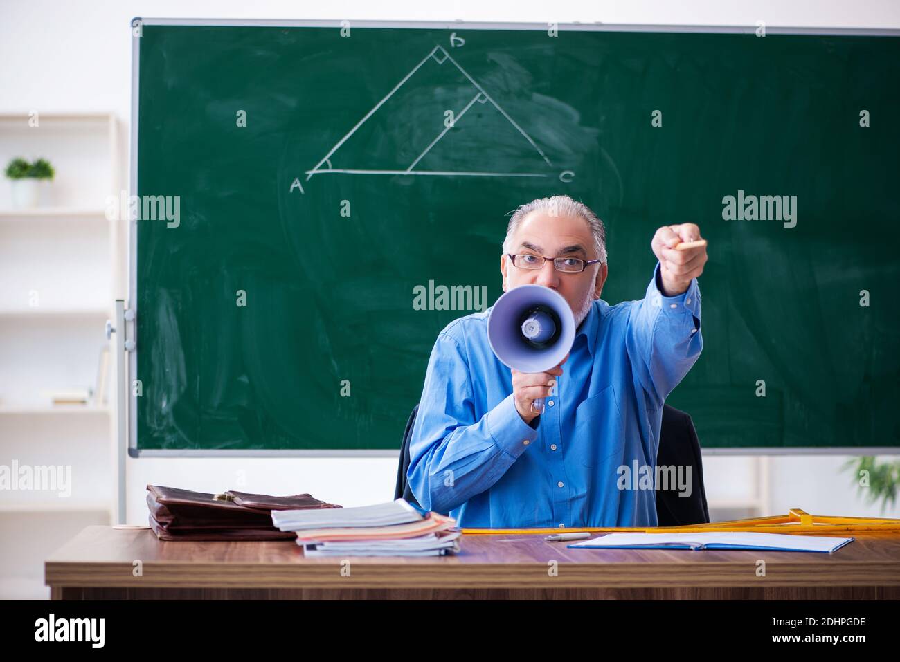 Angry male math teacher holding megaphone Stock Photo - Alamy