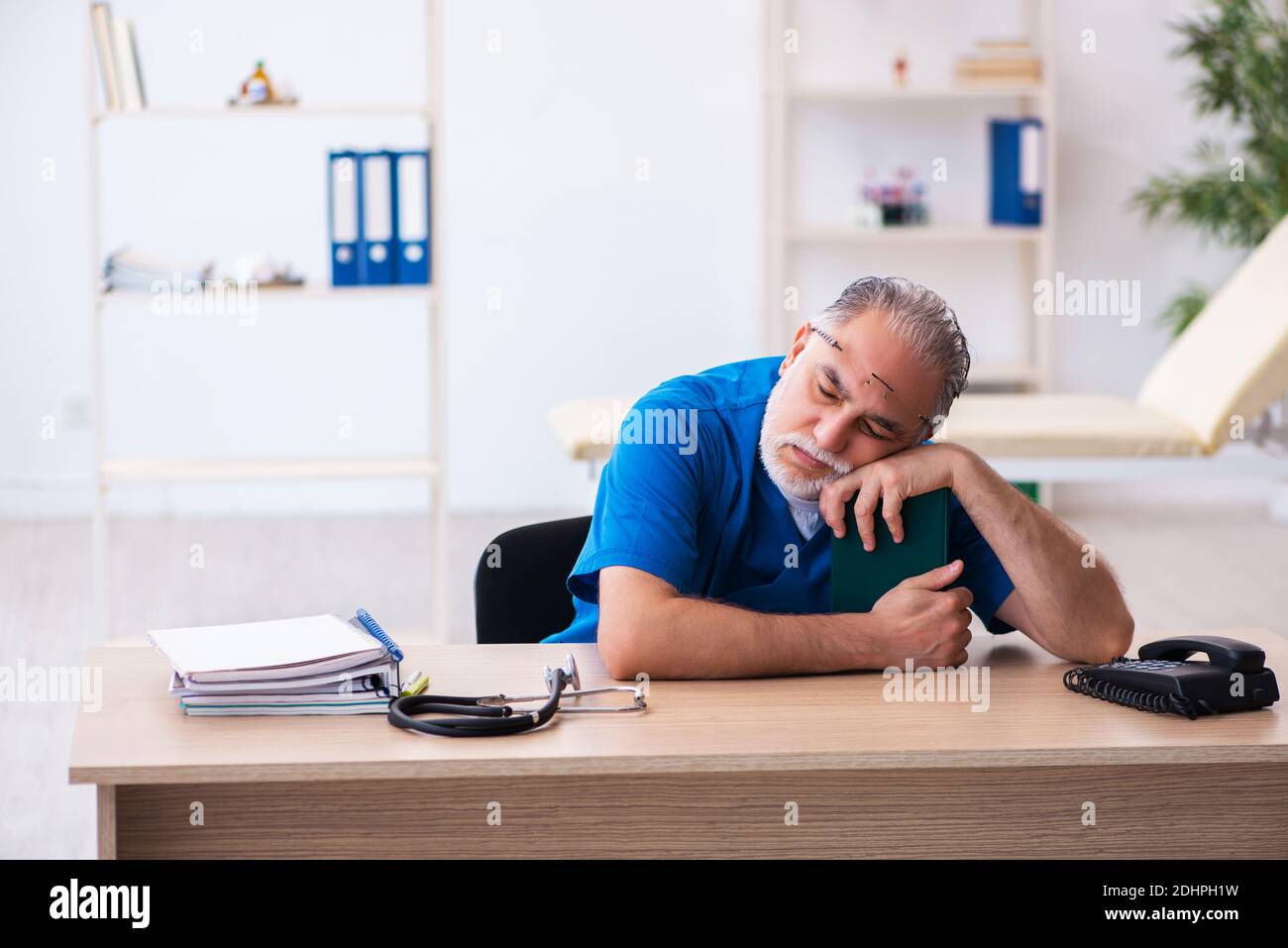 Senior male doctor extremely tired after night shift Stock Photo - Alamy