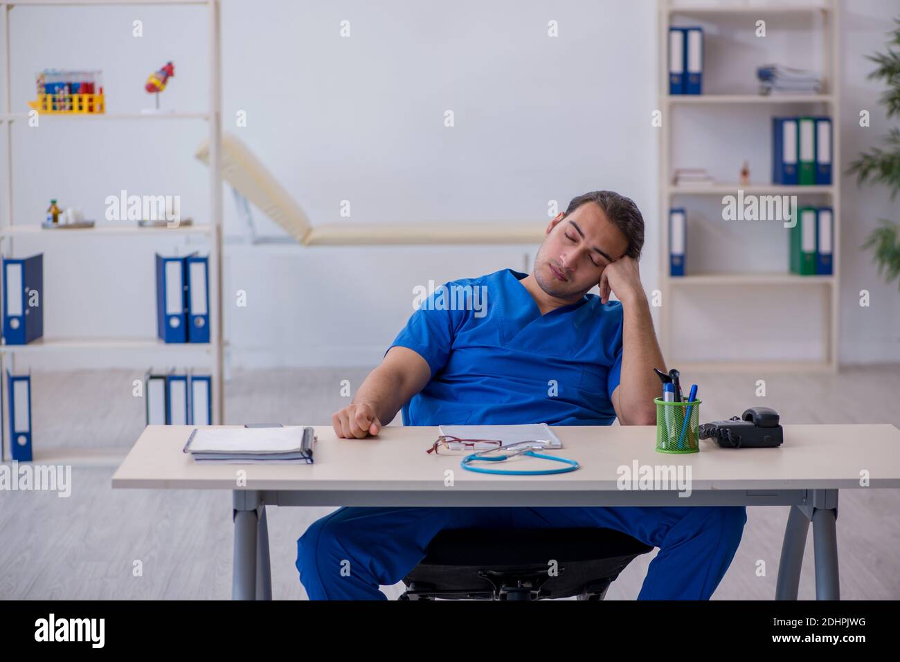 Young doctor being extremely tired in the clinic Stock Photo - Alamy