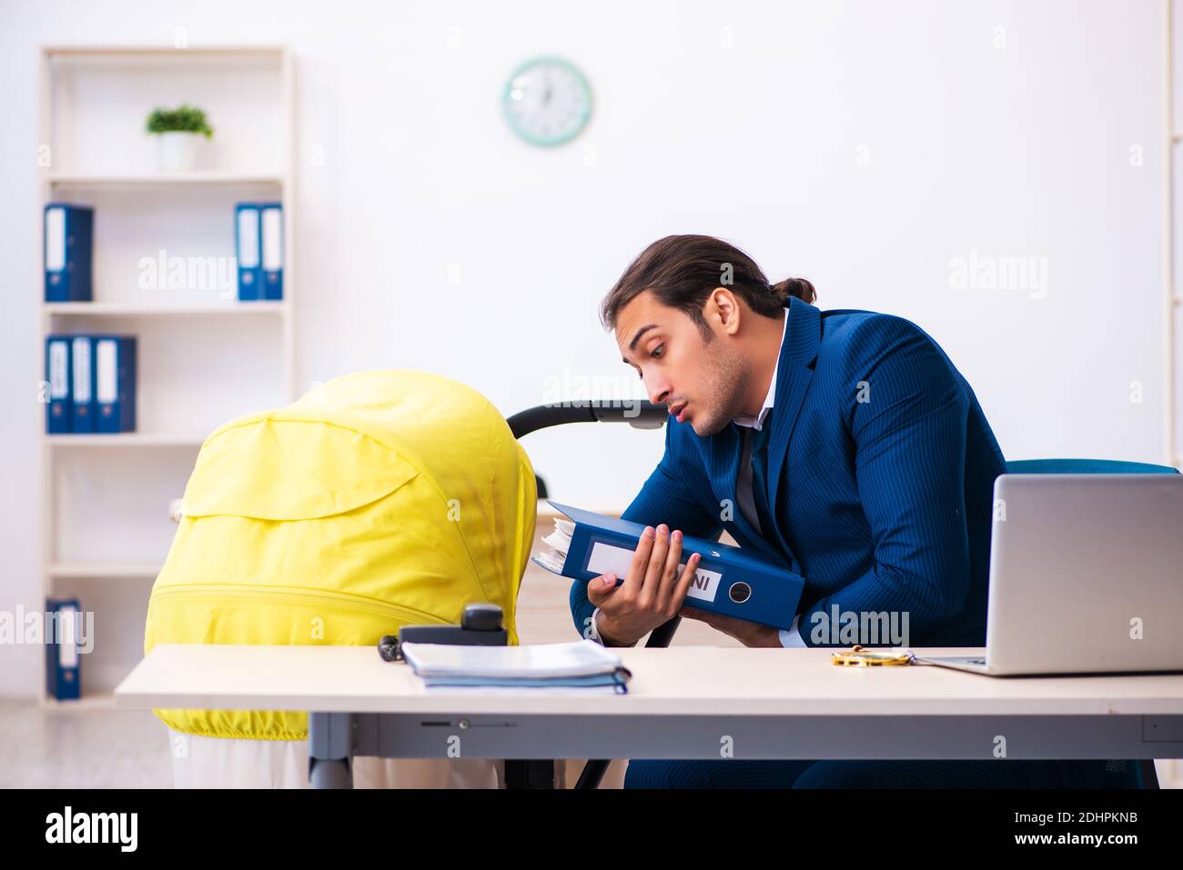 Young employee looking after kid at workplace Stock Photo - Alamy