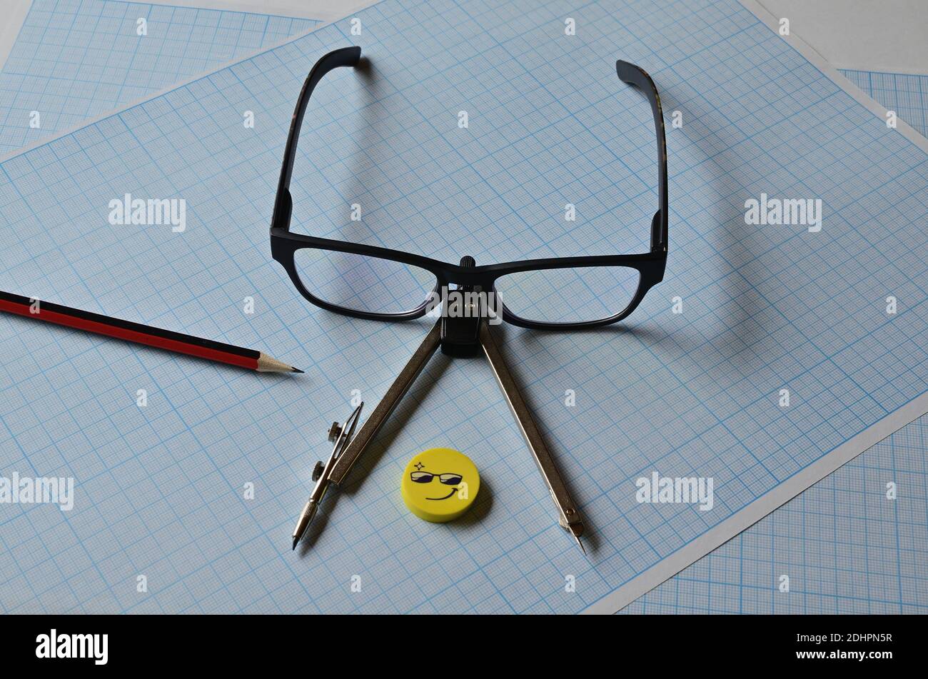Compass, pencil, and eraser points on the blue graph paper for ...