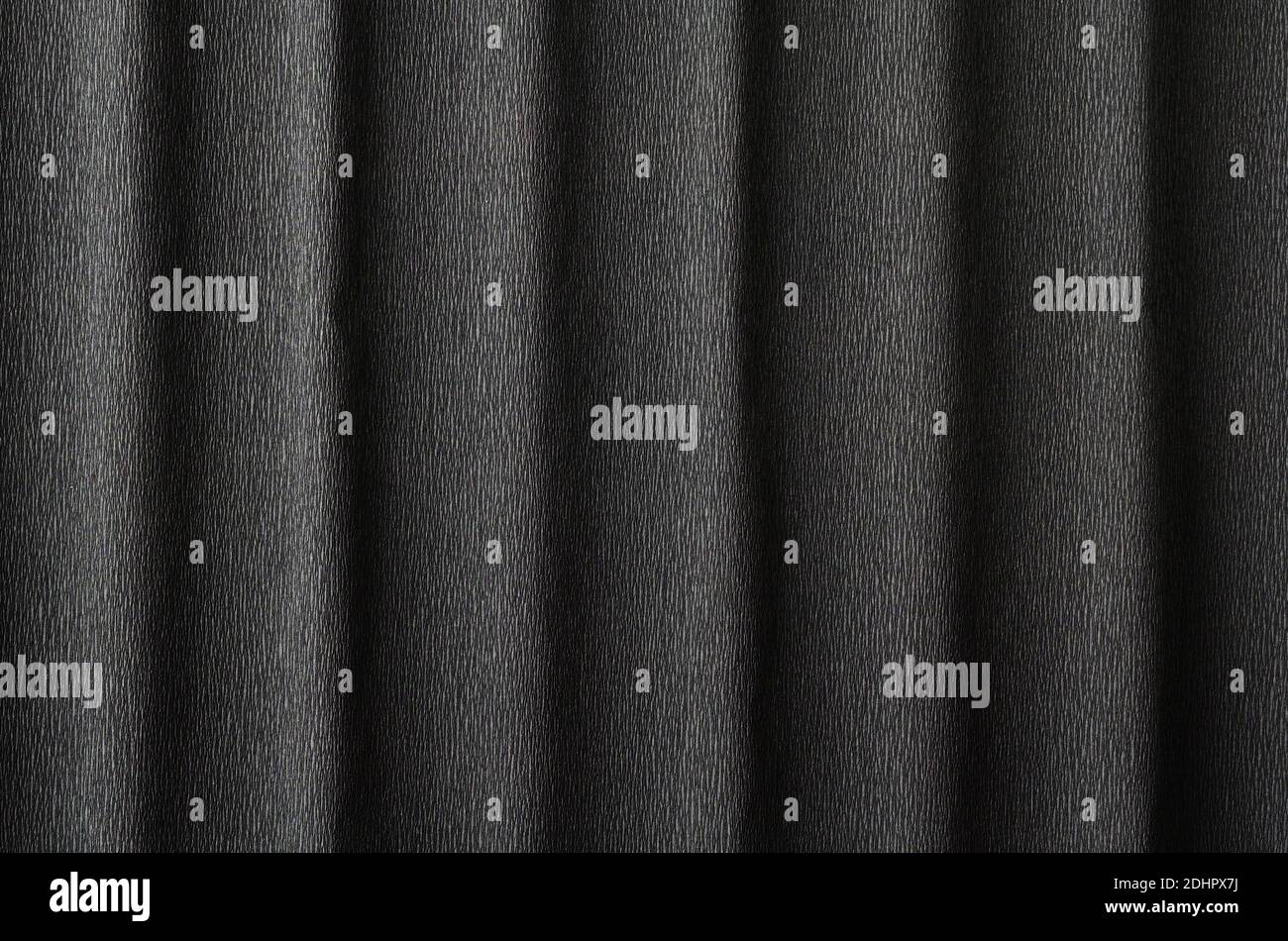 Black crepe paper background with vertical waves and a small pattern ...