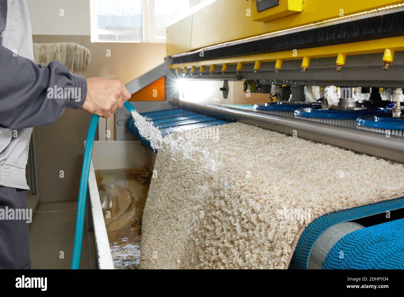 Male worker cleaning carpet on automatic washing machine equipment and ...