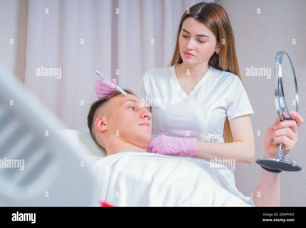 Male cosmetics. Good looking man receiving face treatment at luxury spa ...