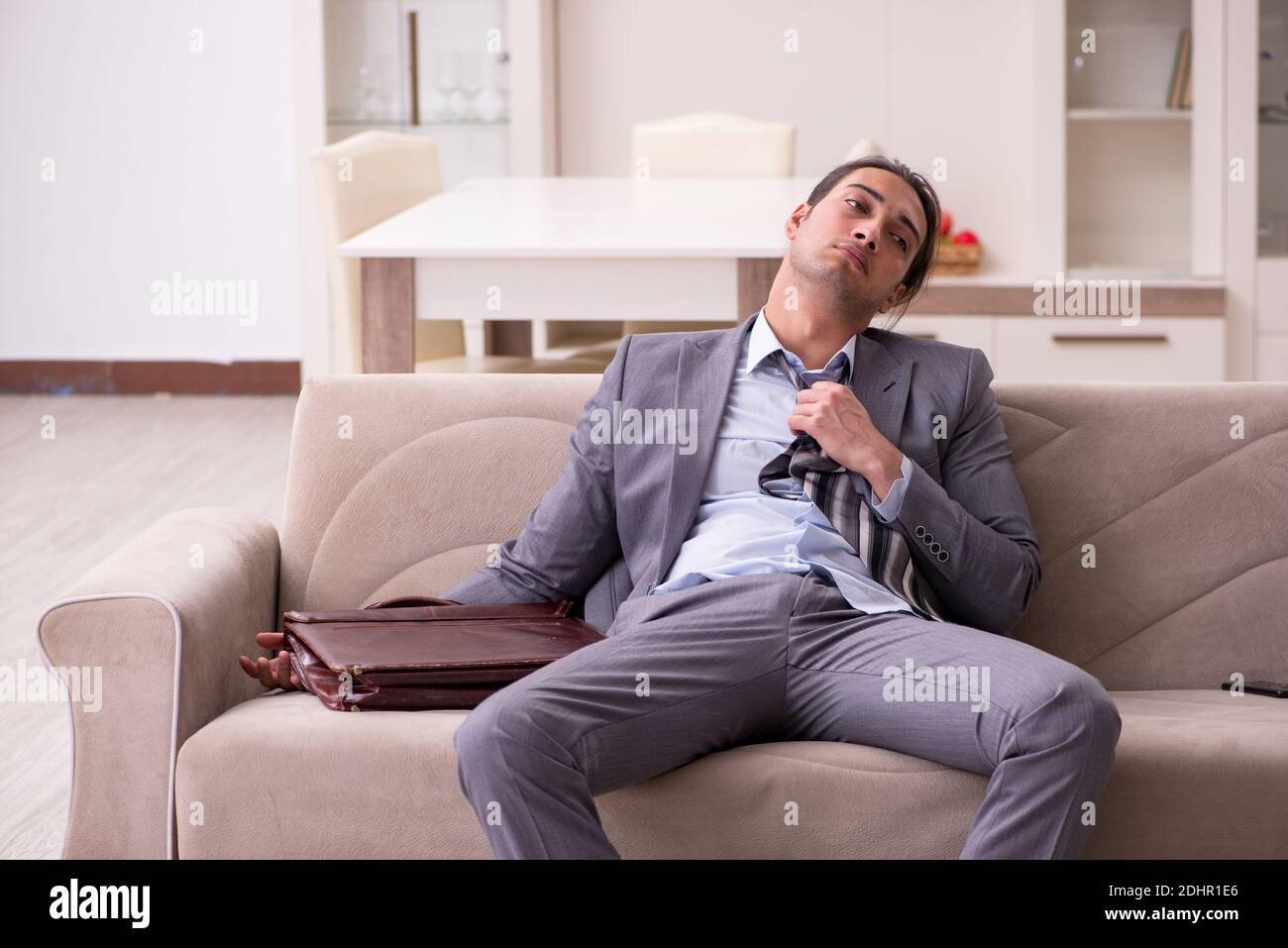 Tired businessman coming home after working day Stock Photo - Alamy