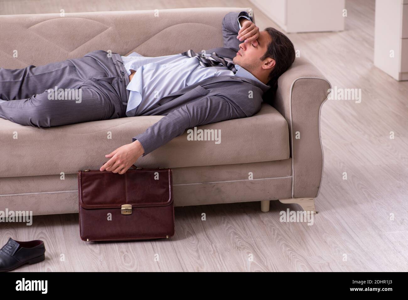 Tired businessman coming home after working day Stock Photo - Alamy