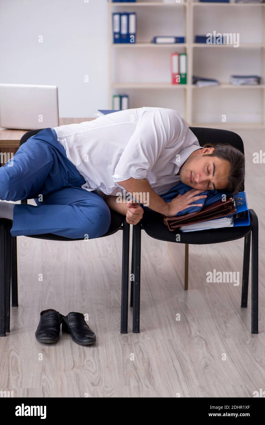 Young employee sleeping in the office on chairs Stock Photo - Alamy