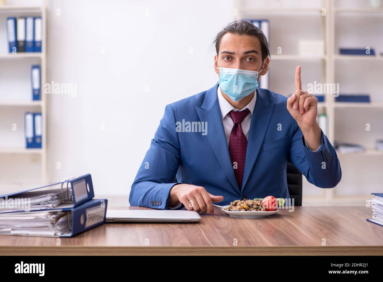 Hungry employee eating buckwheat during break Stock Photo - Alamy
