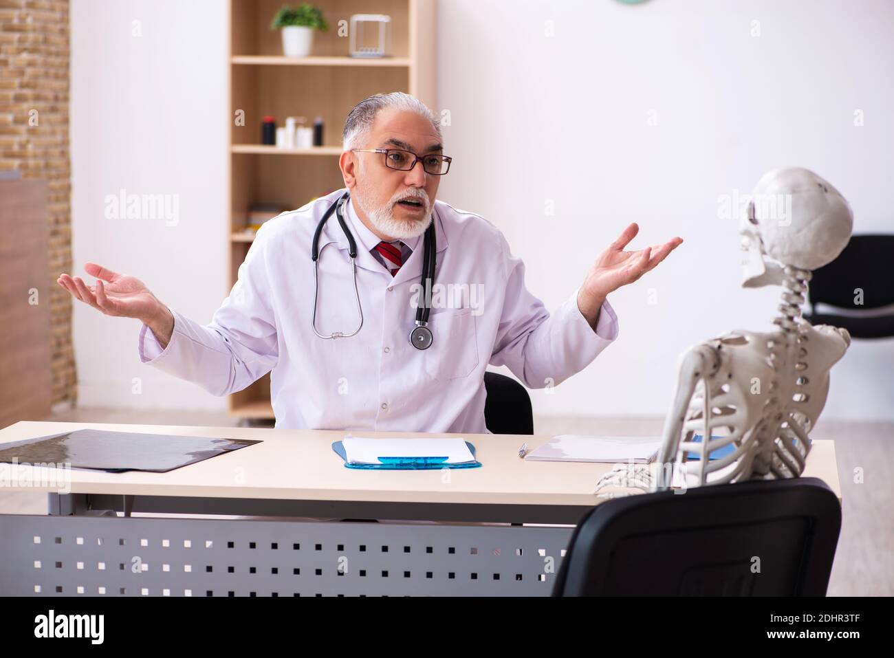 Old doctor and skeleton patient in the clinic Stock Photo - Alamy