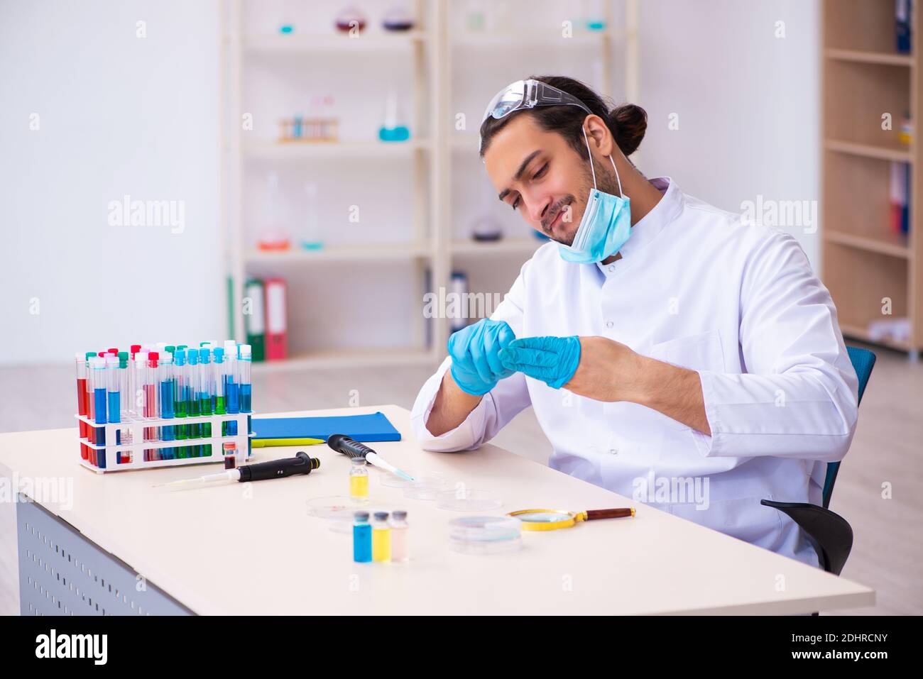 Scientist in laboratory putting covid hi-res stock photography and ...