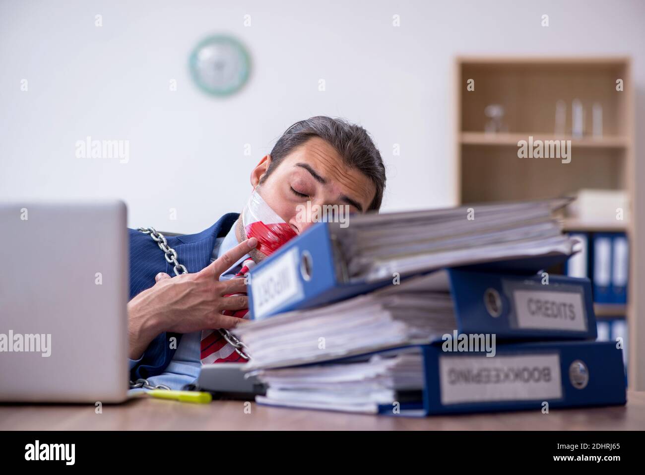 Chained employee unhappy with excessive work in the office Stock Photo ...