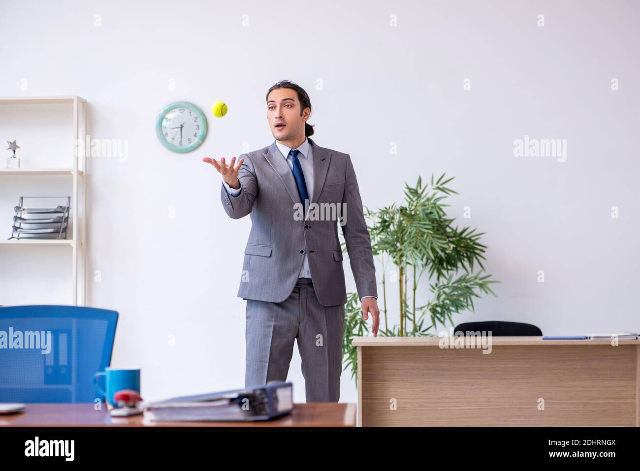Male employee juggling with tennis ball in the office Stock Photo - Alamy