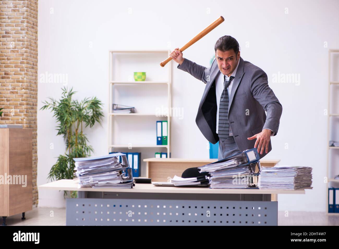 Male employee angry with excessive work holding baseball bat Stock ...